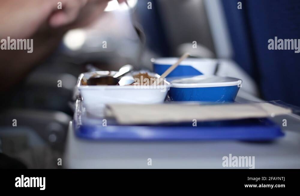 Man eating meal on plane. Food served in a passenger aircraft ...