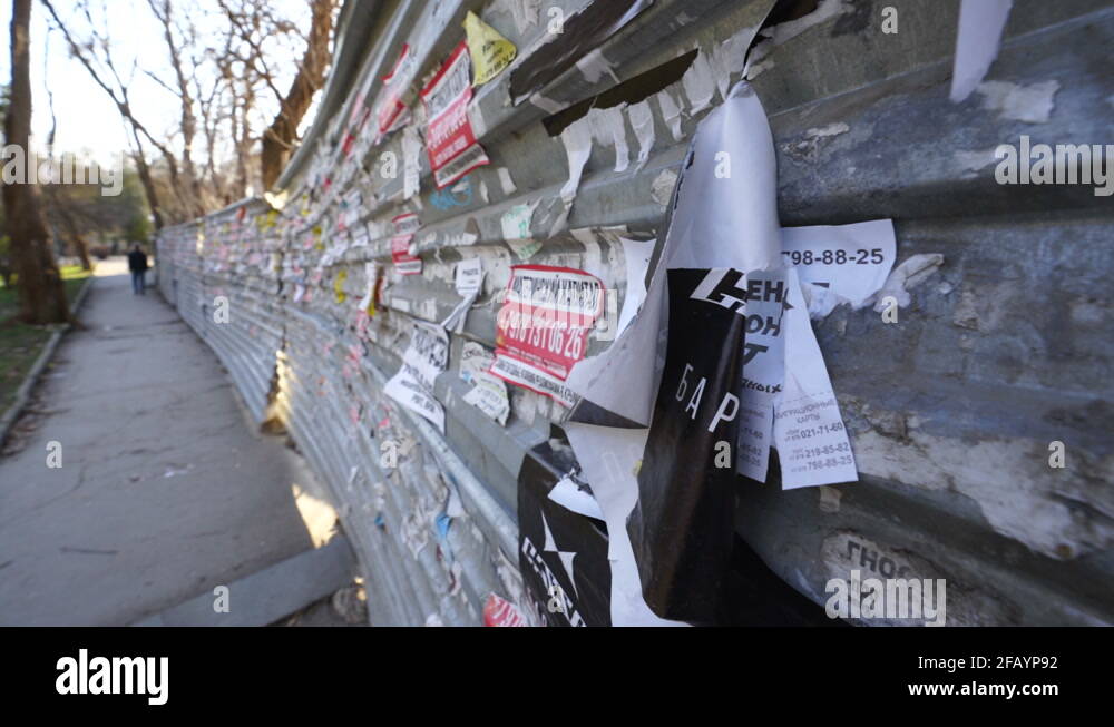 Torn advertisement tear off posters with text in Russian on a metal ...