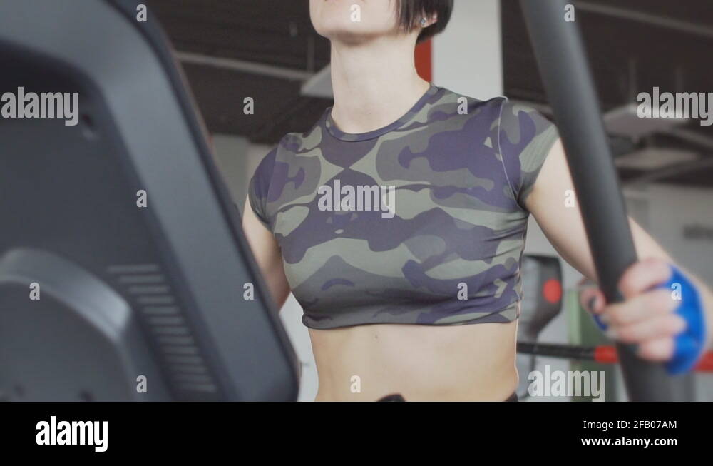 Close up of young short hair style woman running on a treadmill in a ...