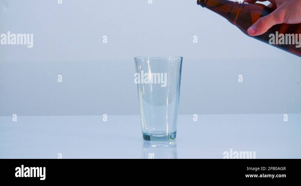 Slow motion of a bottle of beer being poured into a pint glass Stock ...