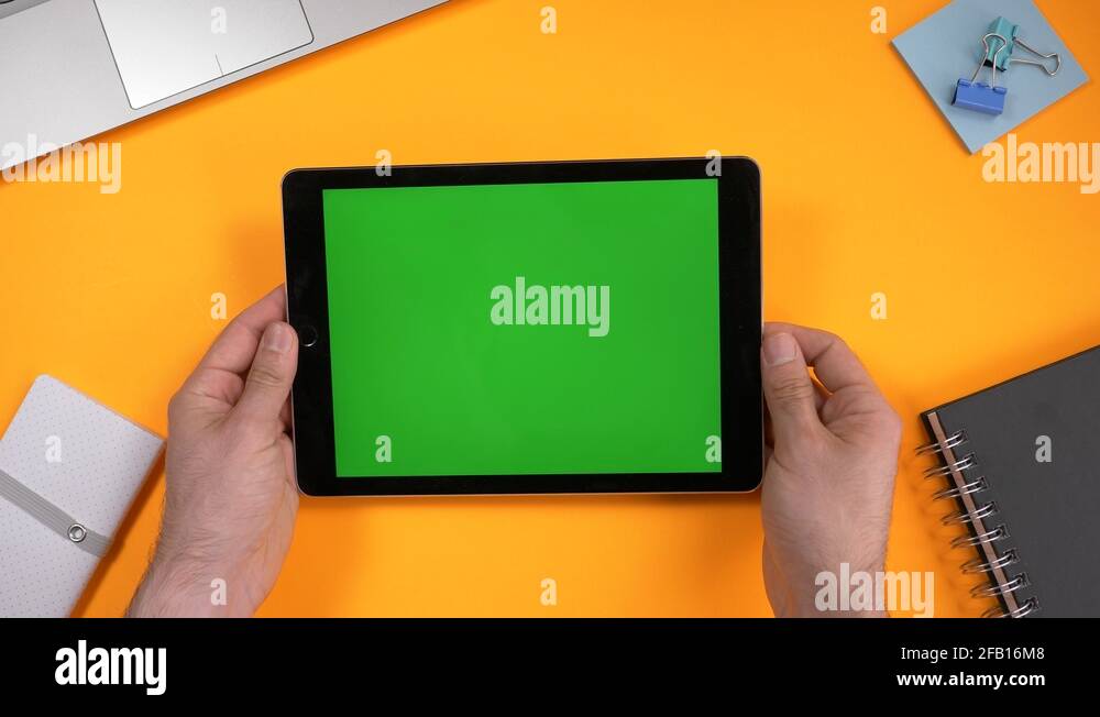 Holding a Tablet With Green Screen Top View Orange Desk Stock Video ...