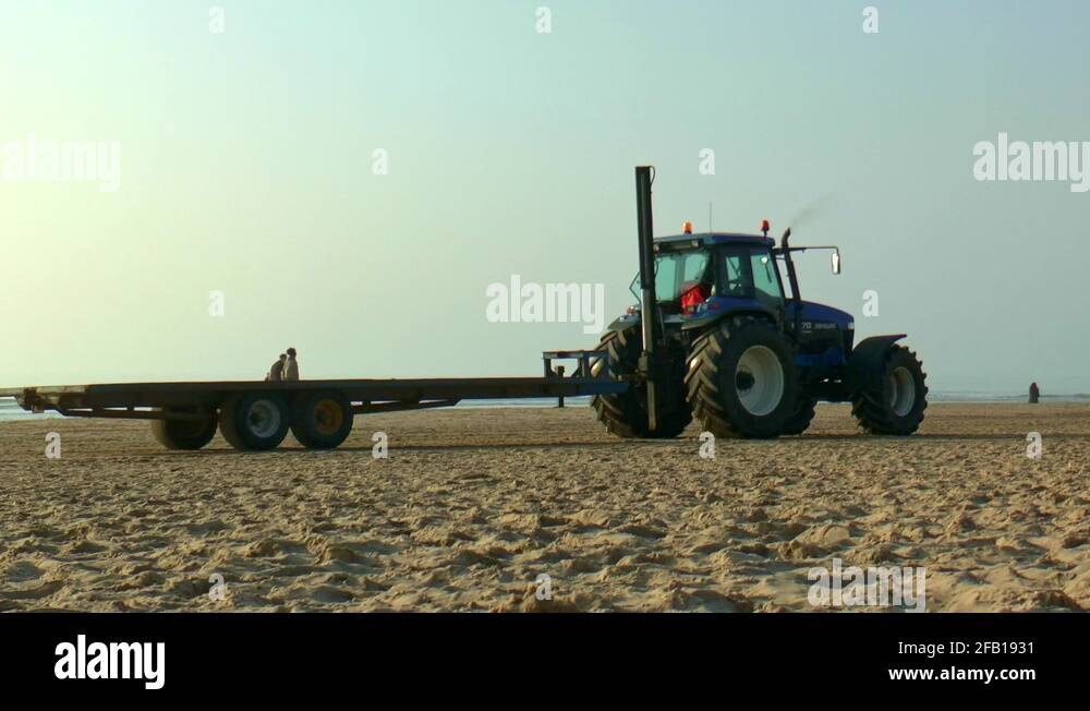 Tractor on the beach takes a turn Stock Video Footage - Alamy