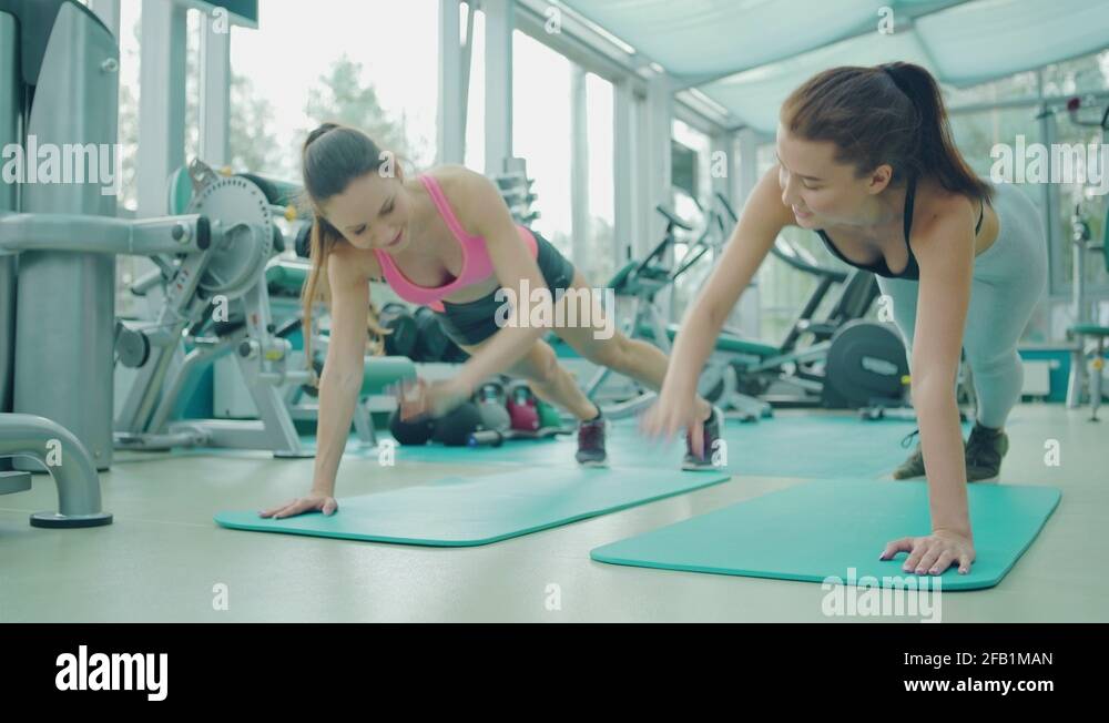 Two women giving high five while doing full plank Stock Video Footage ...