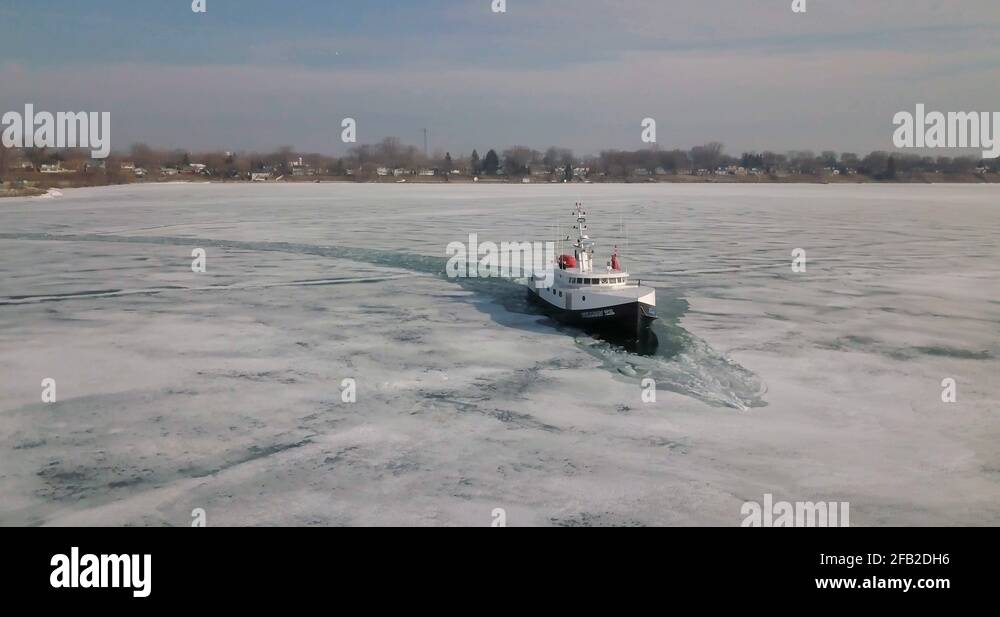 A powerful icebreaker ship, digging a path on the frozen surface, as a ...