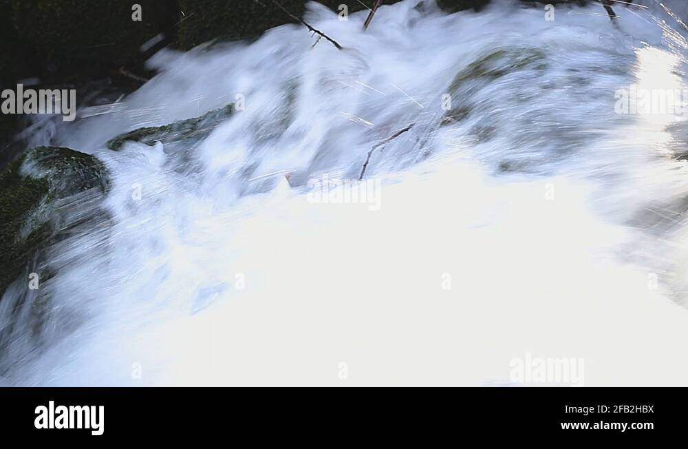 White, rough water running down the rocks like waterfall, splashing all ...