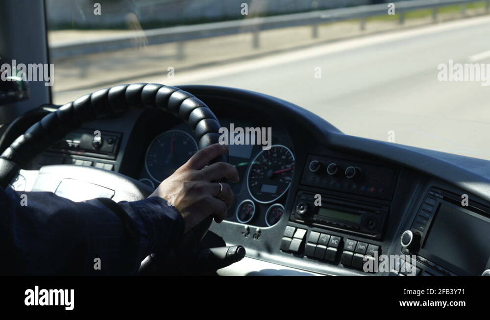 Bus driver behind the wheel of long-distance coach. Man driving ...