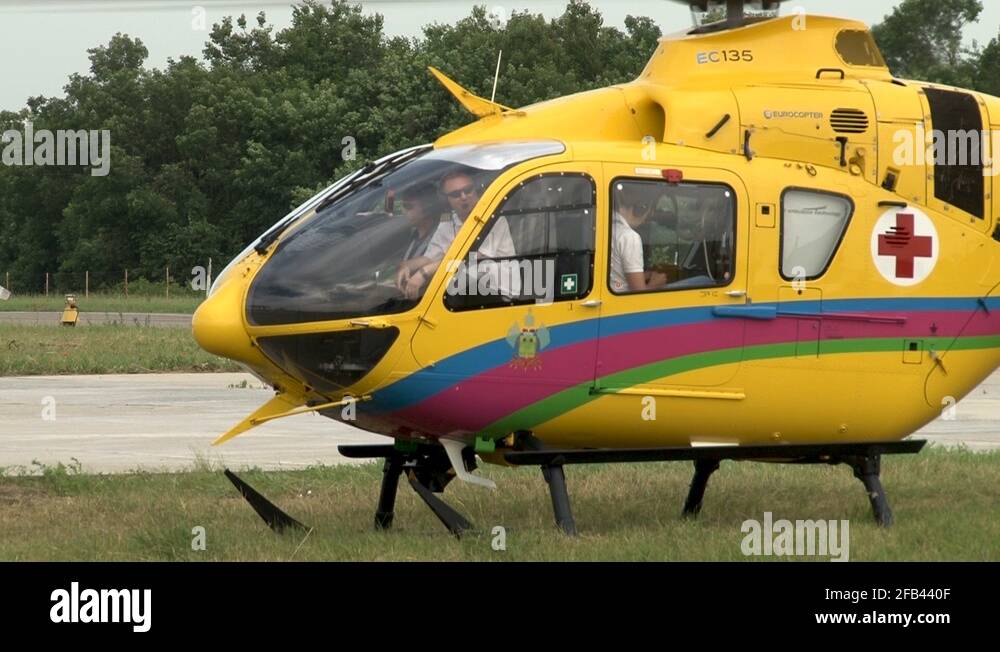 Eurocopter EC135 medical helicopter stands in field with a running ...