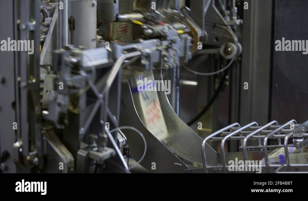 Milk packaging line. Dairy products in tetra packaging are moving along ...