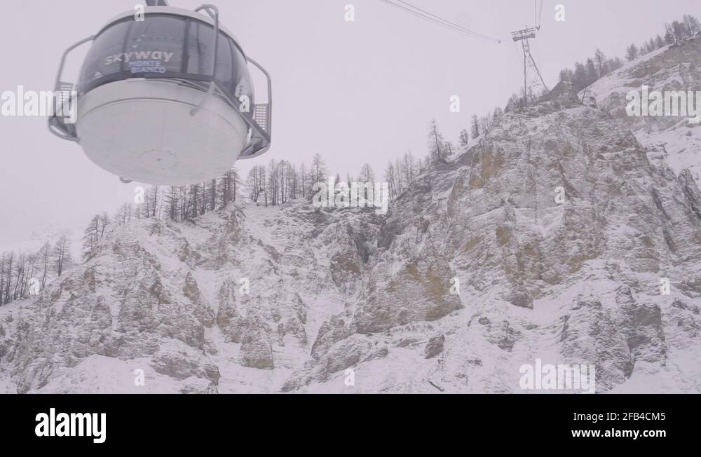 Panning camera view from cabin window of Skyway going up to Mont Blanc ...