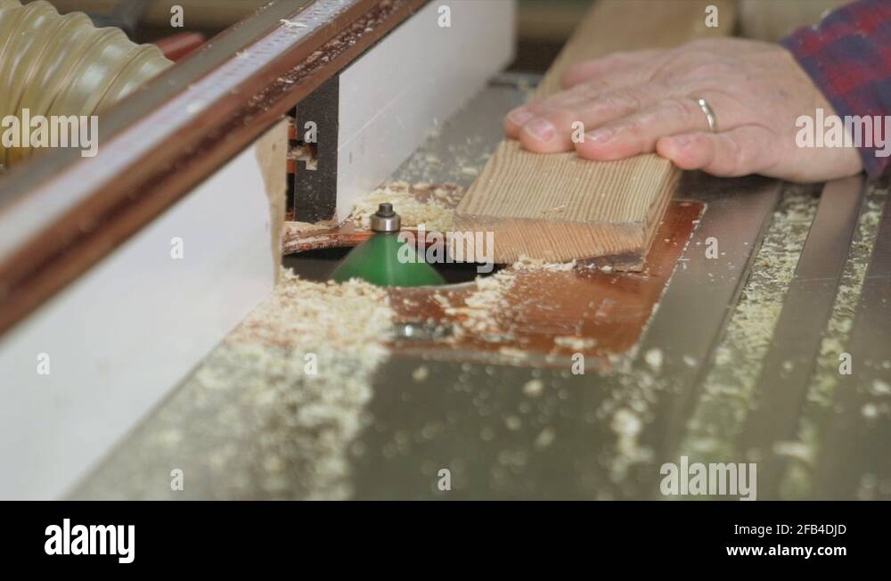 Zooming in shot of a Carpenter using an Inverted Router table in a ...