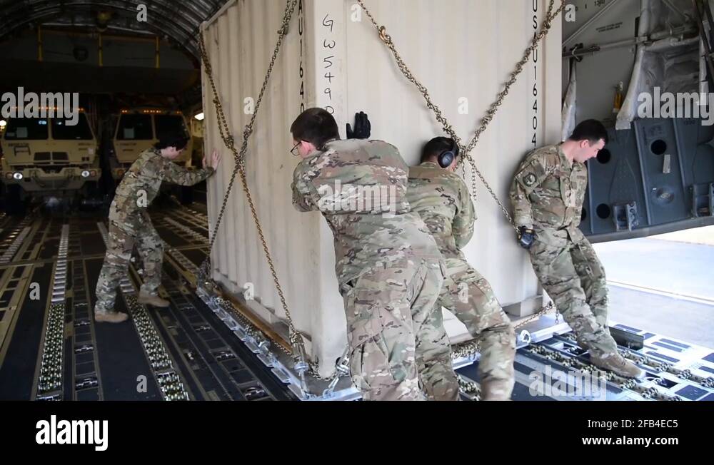 U.S. soldiers load cargo and military vehicles in C-17 Globemaster III ...