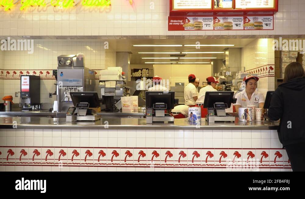 Static shot of customer ordering at In-n-Out with staff working in ...