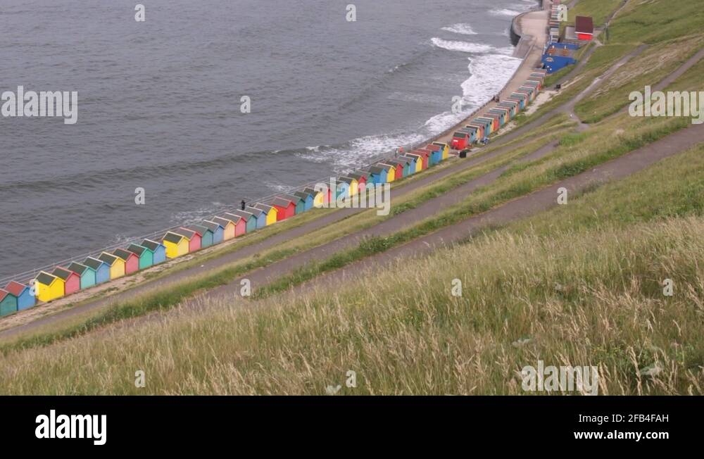 Coast outside Whitby harbour, showing beach huts, pavilion and piers ...