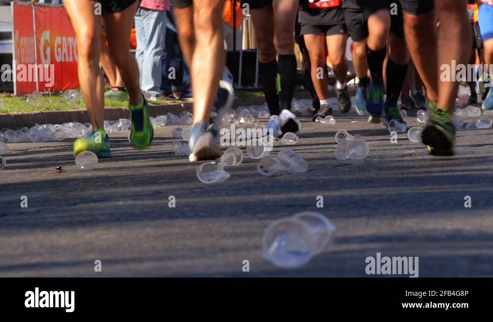 Low shot of the feet of runners on a marathon with lots of plastic ...