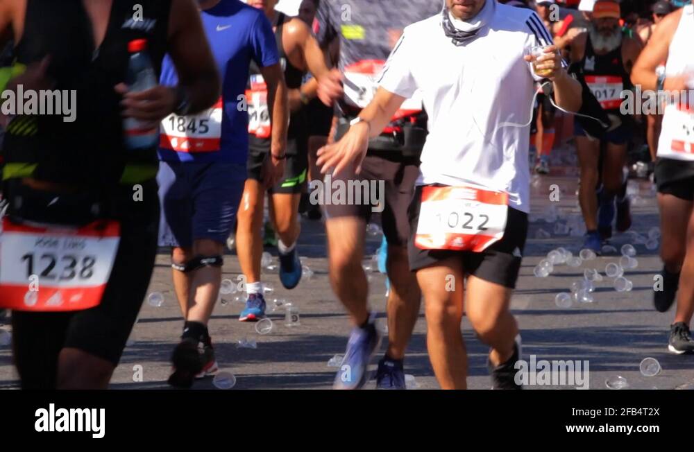 Participants of a marathon surrounded by plastic waste of the race ...