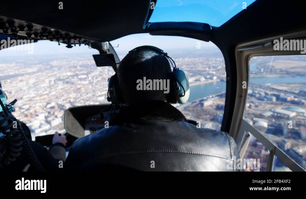 Capture of helicopter pilot filmed from behind flying a helicopter with ...