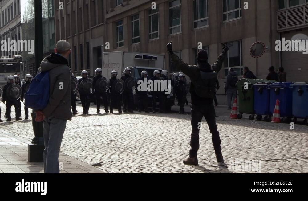 an activist sticks out his middle fingers at the riot police during a ...