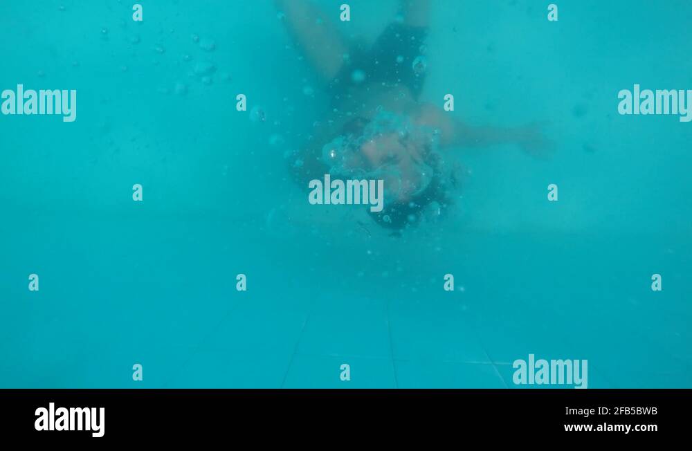 Beautiful pictures of young man playing in the pool, submerged with ...
