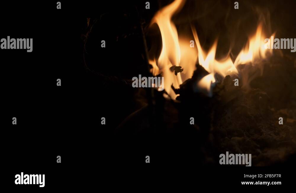 Fire flames slowly burning scrap in pitch darkness, close up shot Stock ...