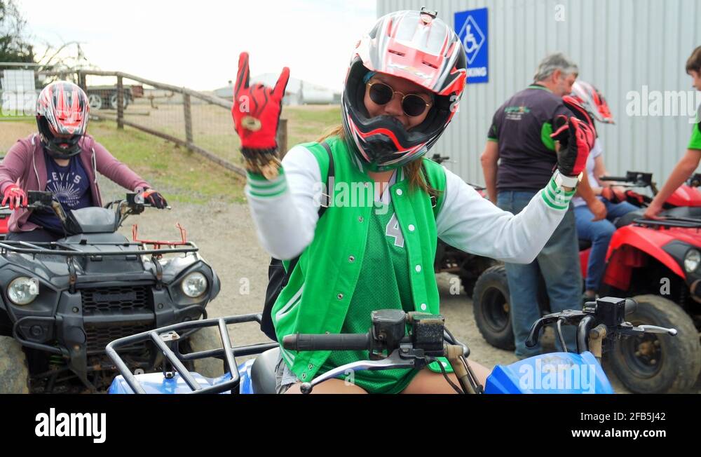 Girl on quad bike, standing still, excited to start the rally. Girl ...