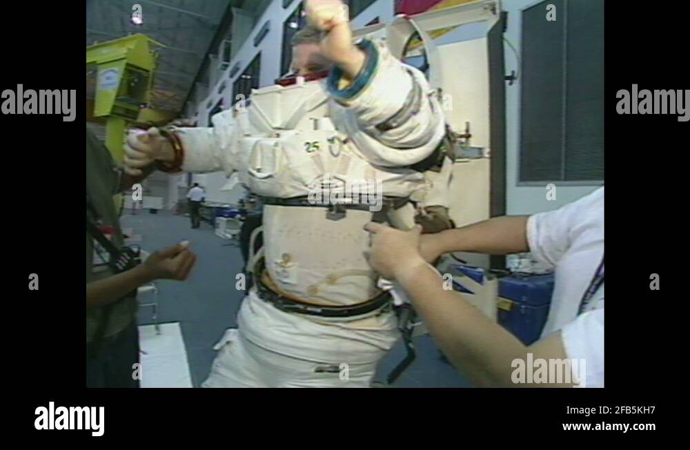 2000s: Two male astronauts are fitted into space suits and helmets ...