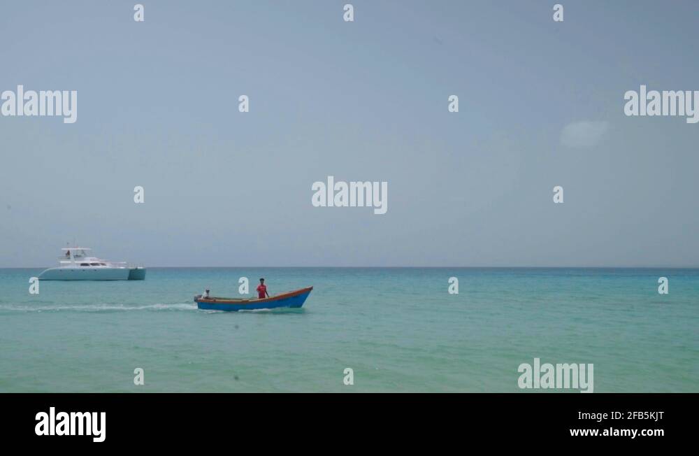 A Small Open Boat Speeds Off in Tropical Ocean on Cloudless Day in ...