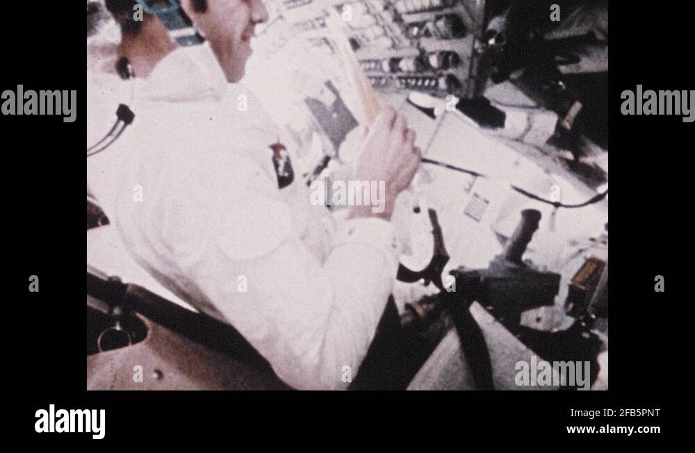 1960s: Astronaut in spacecraft floats bag of food to other astronaut ...