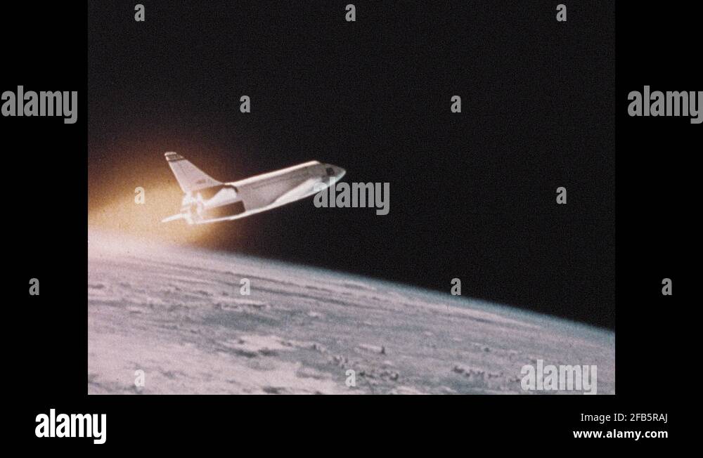 1960s: Space shuttle traveling over Earth. Rear view of shuttle flying ...