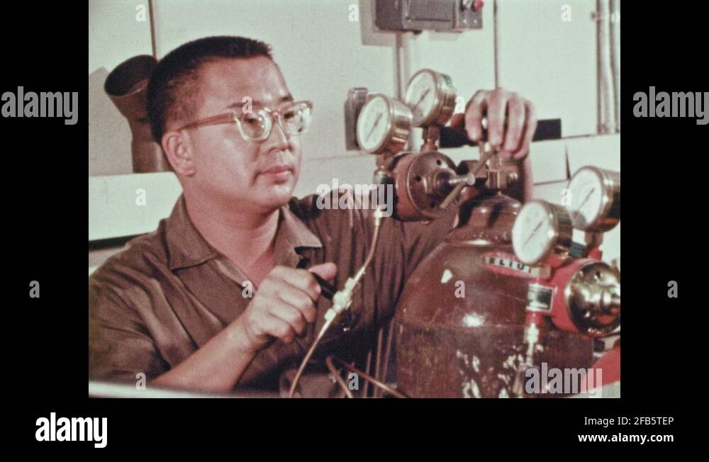 1960s: Man adjusts valve on tank. Man presses button and turns dial ...