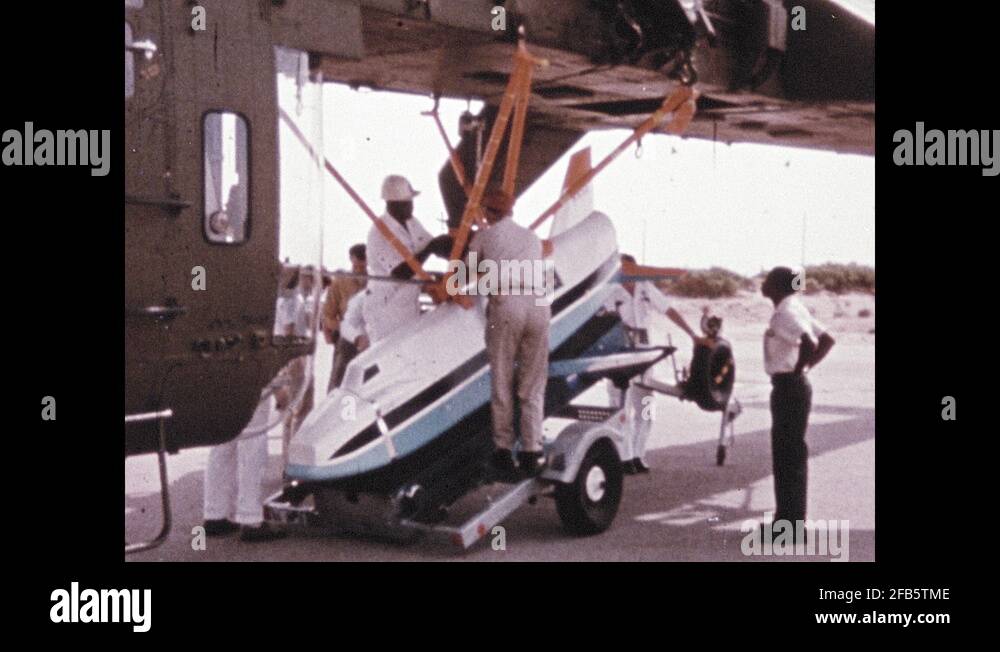 1960s: Men attaching model of space shuttle to plane. Aerial view ...