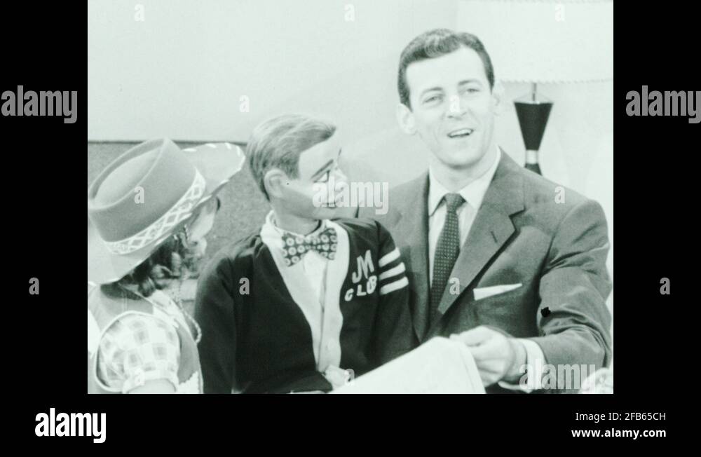 1960s: Man speaks to ventriloquist dummy. Girl in cowboy attire smiles ...