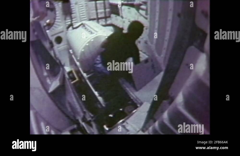 1980s: Astronaut inside space shuttle, opens hatch, places something ...