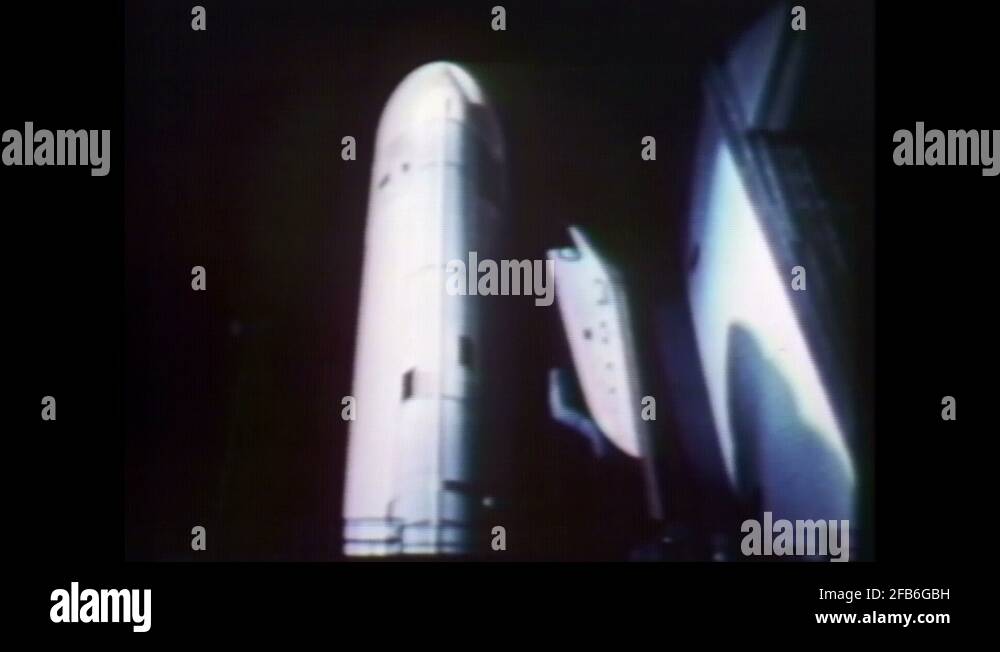 1980s: UNITED STATES: space shuttle on gantry at night. Man stands by ...