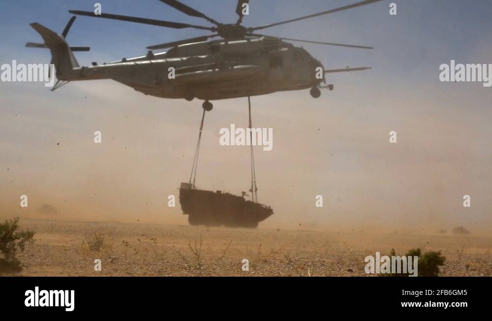 CH-53 Super Stallion creates sand storm while lifting armored vehicle ...