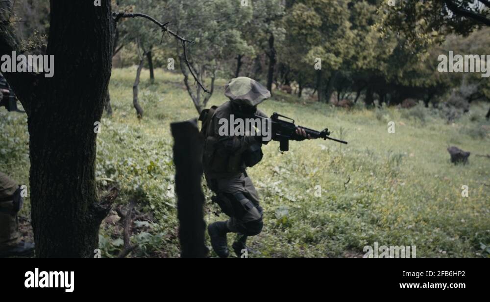 Squad of fully armed commando soldiers during combat in a forest ...