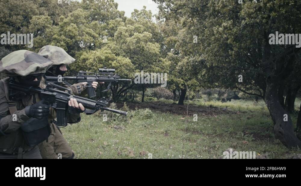 Squad of fully armed commando soldiers during combat in a forest ...