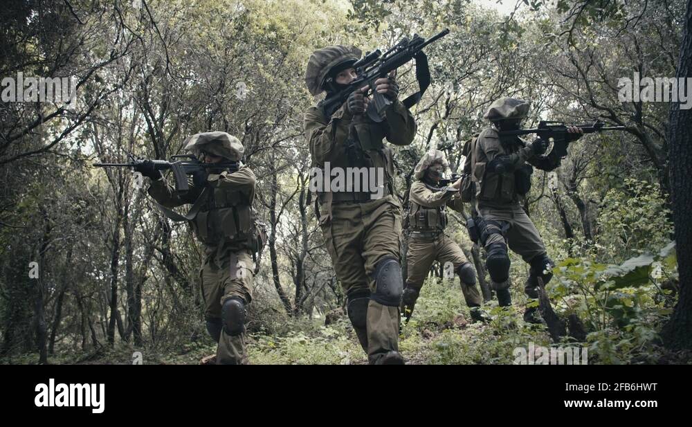 Squad of fully armed commando soldiers during combat in a forest ...
