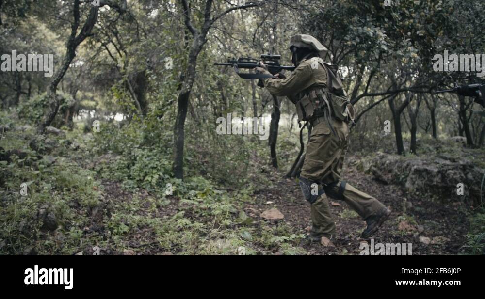 Squad of fully armed commando soldiers during combat in a forest ...