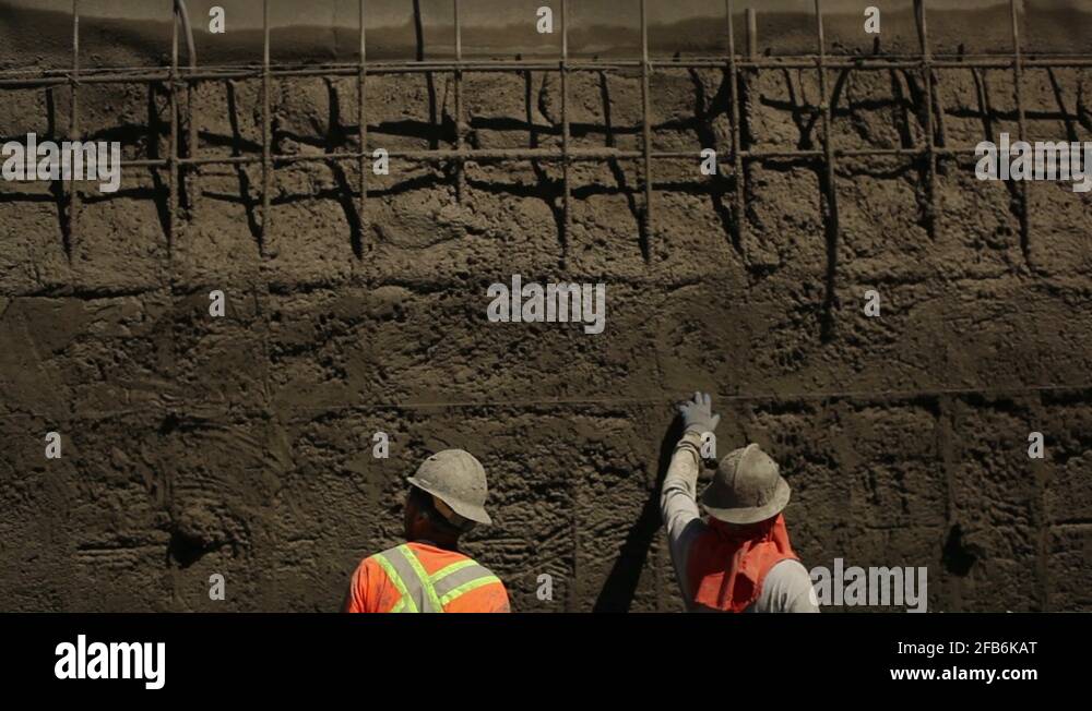 Two Men With Backs Turned Scraping Mud Over Rebar Reinforcement on ...