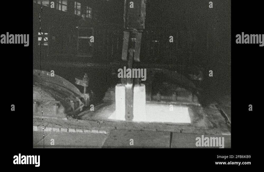 1930s: Mechanical arm moves steel bar from oven. Mechanical arms moving ...