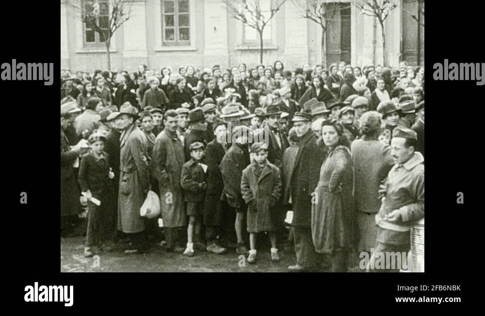 1930s: Crowds of people stand in street. Smoke. Buildings Stock Video ...
