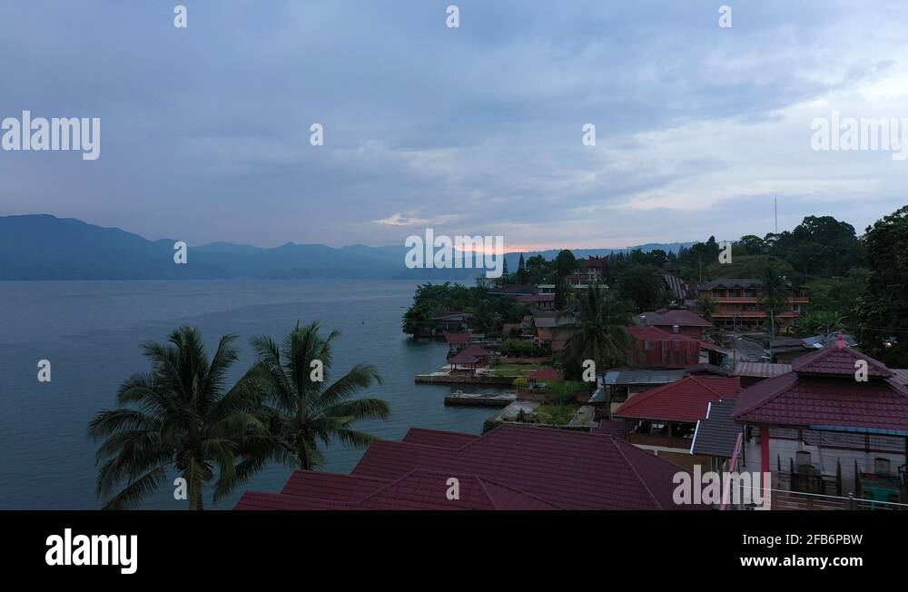 Drone flyover footage of waterfront resorts on Samosir Island on Lake ...