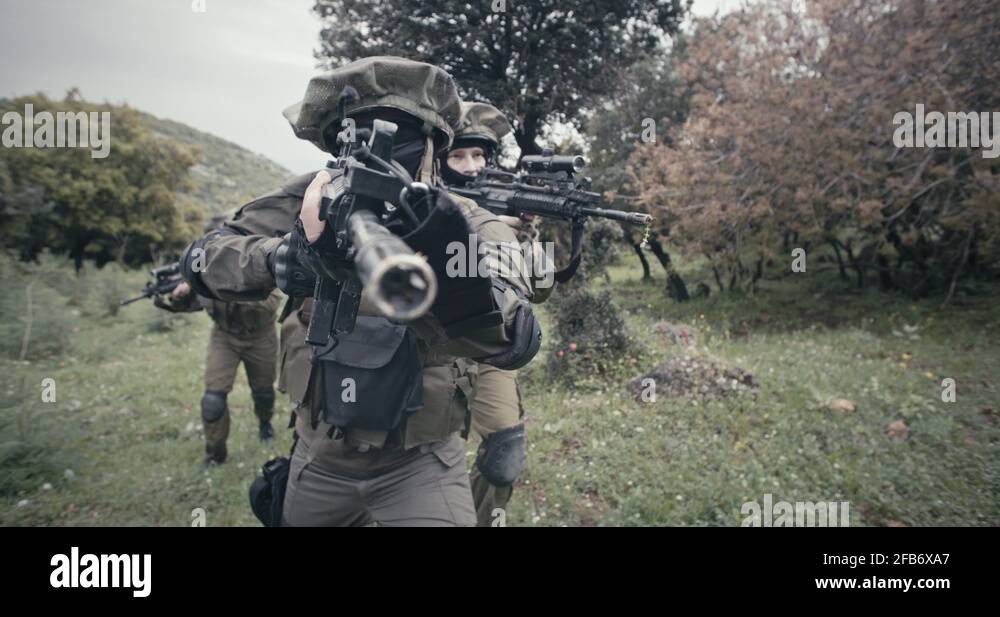 Squad of fully armed commando soldiers during combat in a forest ...