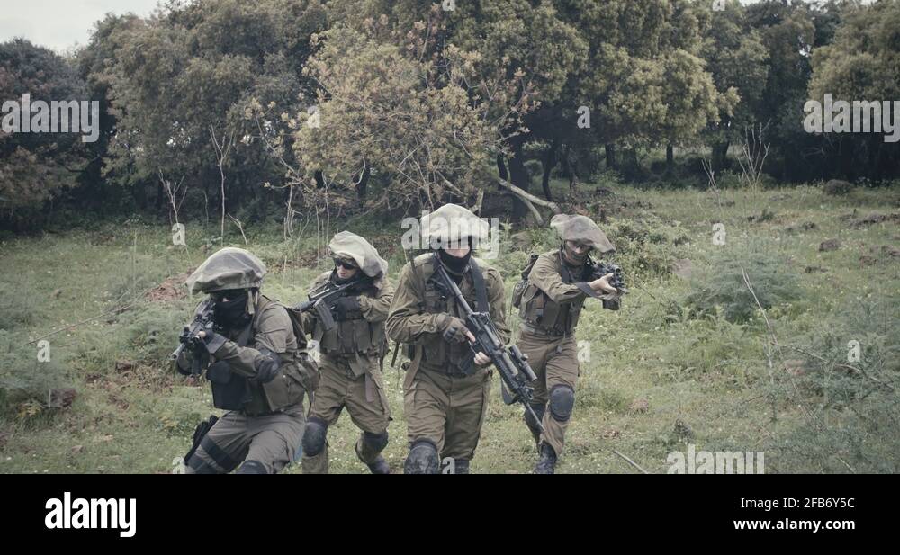 Squad of fully armed commando soldiers during combat in a forest ...