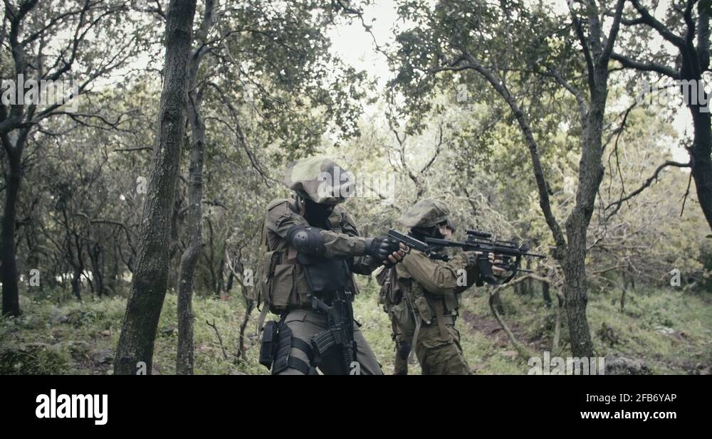 Squad of fully armed commando soldiers during combat in a forest ...