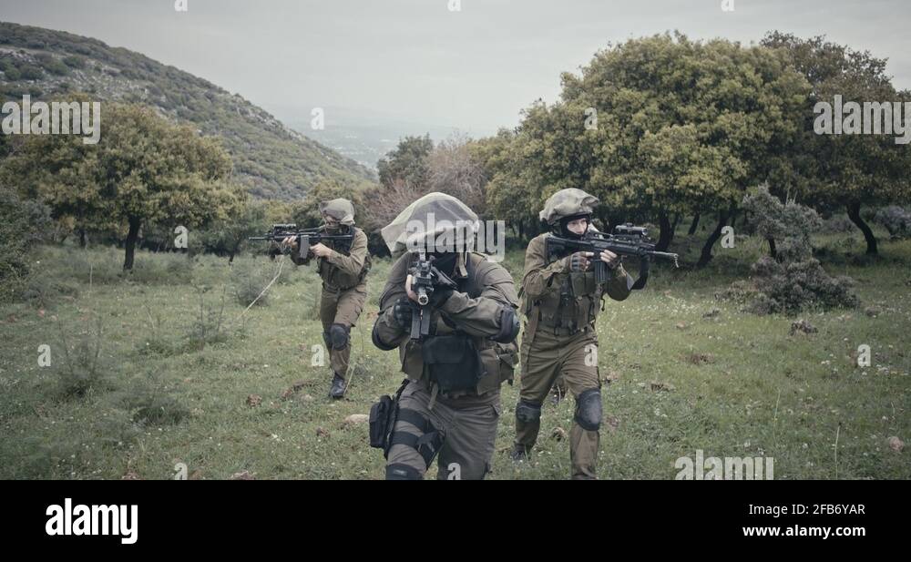 Squad of fully armed commando soldiers during combat in a forest ...
