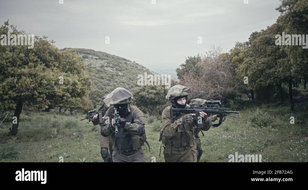 Squad of fully armed commando soldiers during combat in a forest ...