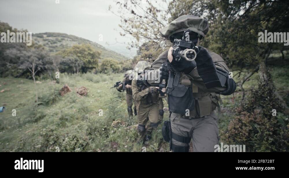 Squad of fully armed commando soldiers during combat in a forest ...