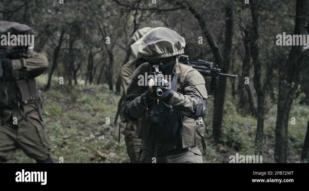 Squad of fully armed commando soldiers during combat in a forest ...