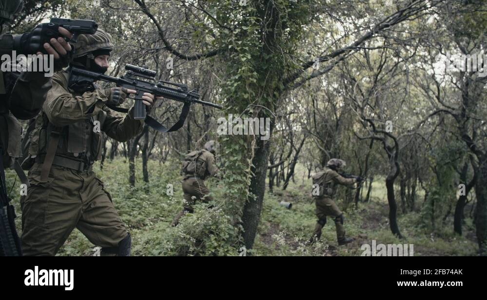Squad of fully armed commando soldiers during combat in a forest ...